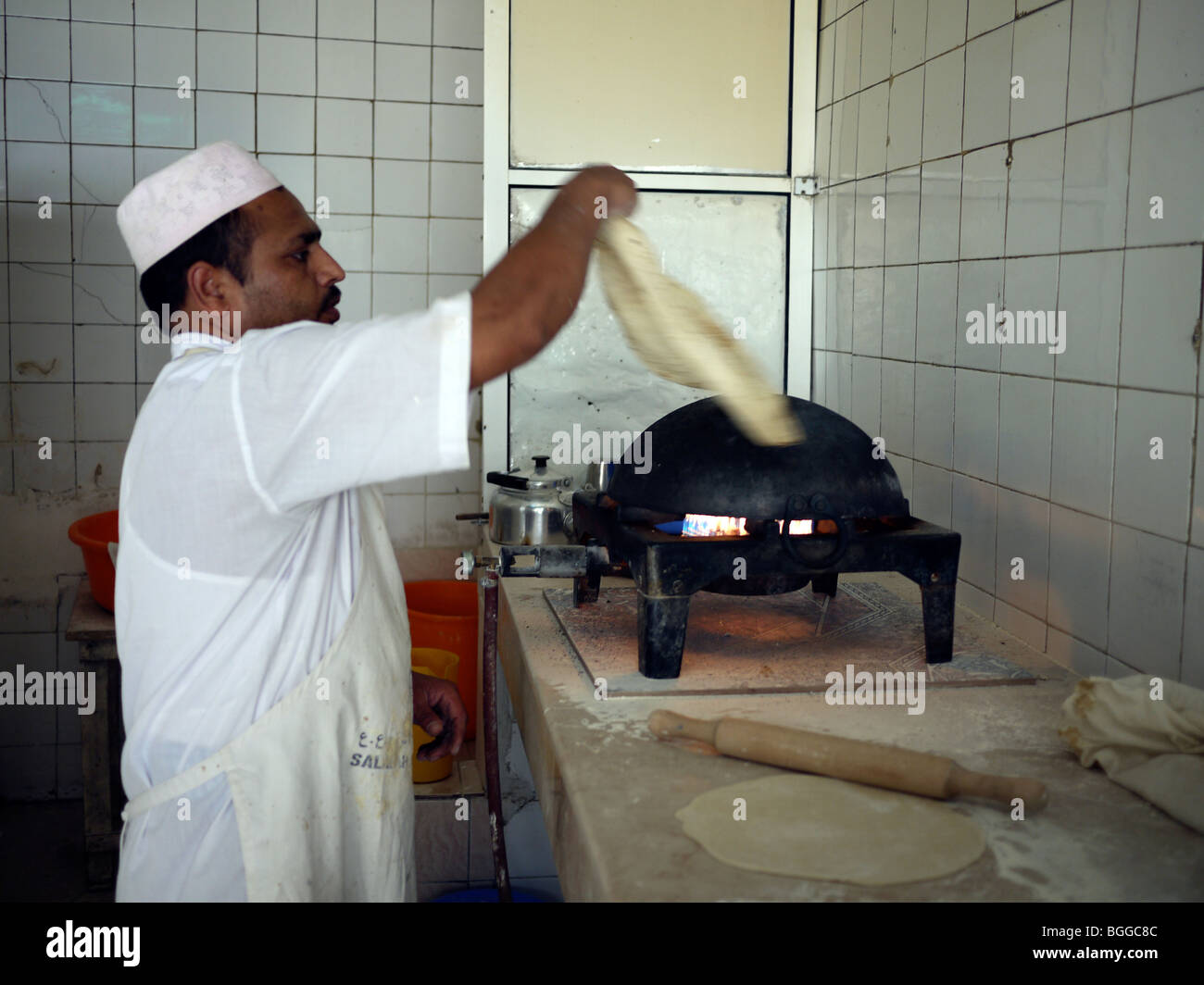 Baker flipping flat bread in Oman bakery Stock Photo - Alamy