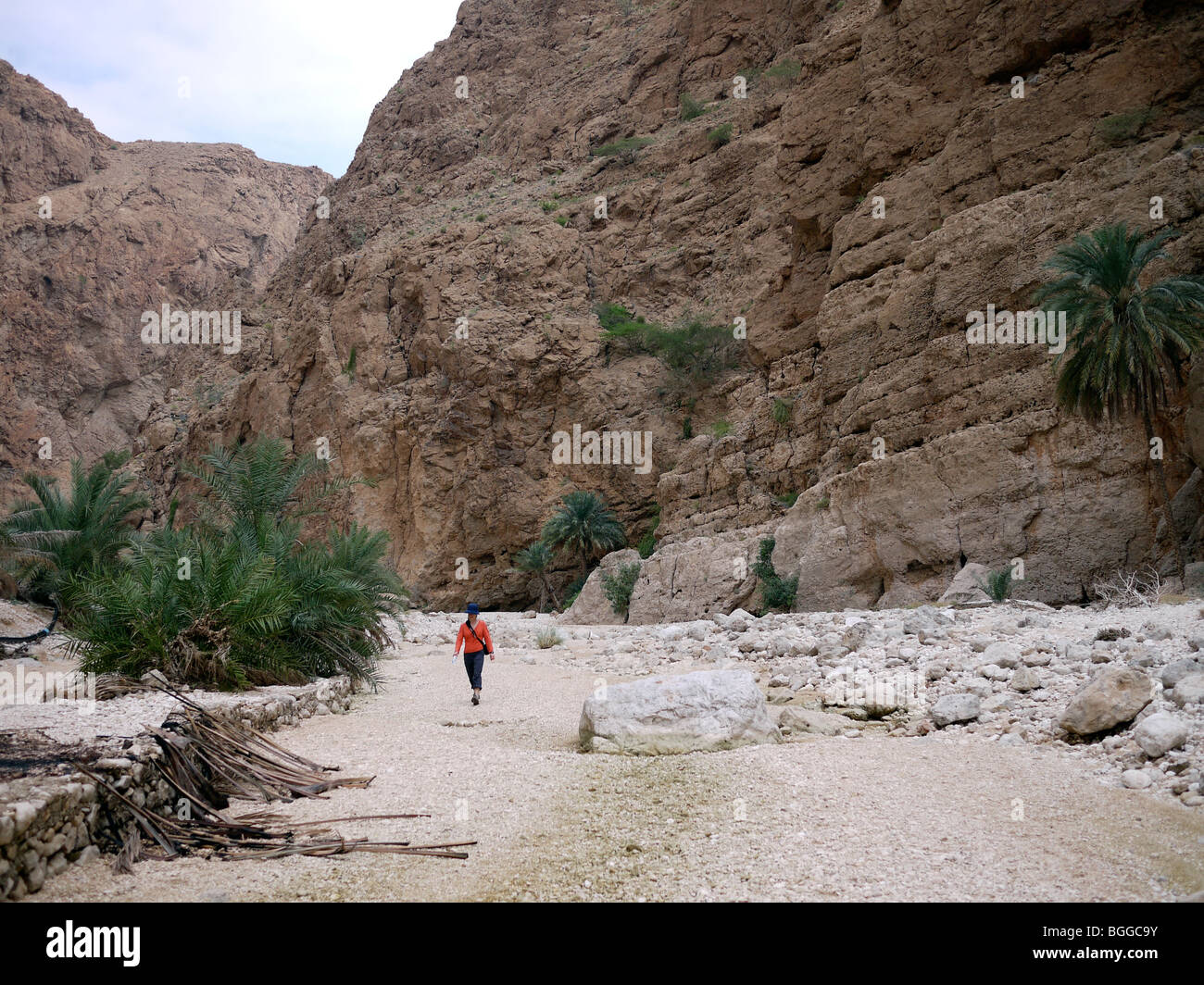 Tourist walking across the sands of Wadi Shab, Oman Stock Photo - Alamy