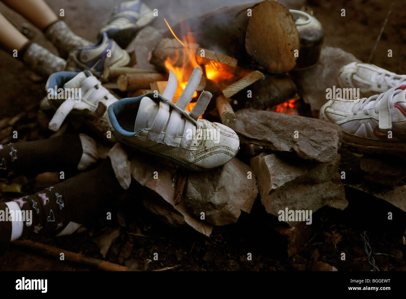 children drying feet around campfire Stock Photo - Alamy