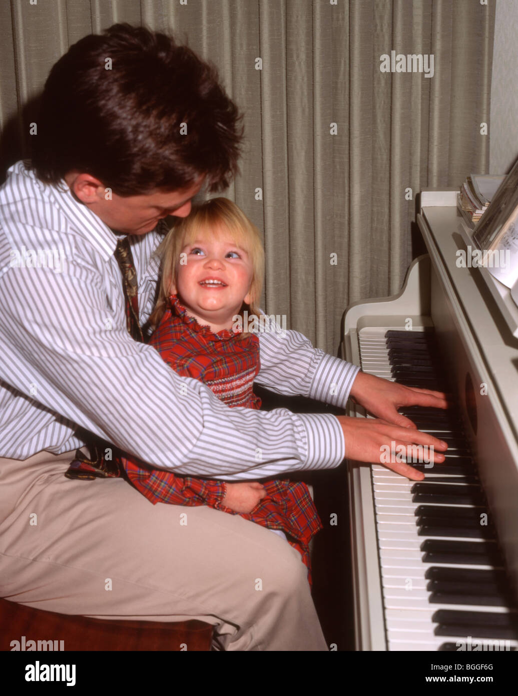 Father playing piano for daughter Stock Photo - Alamy