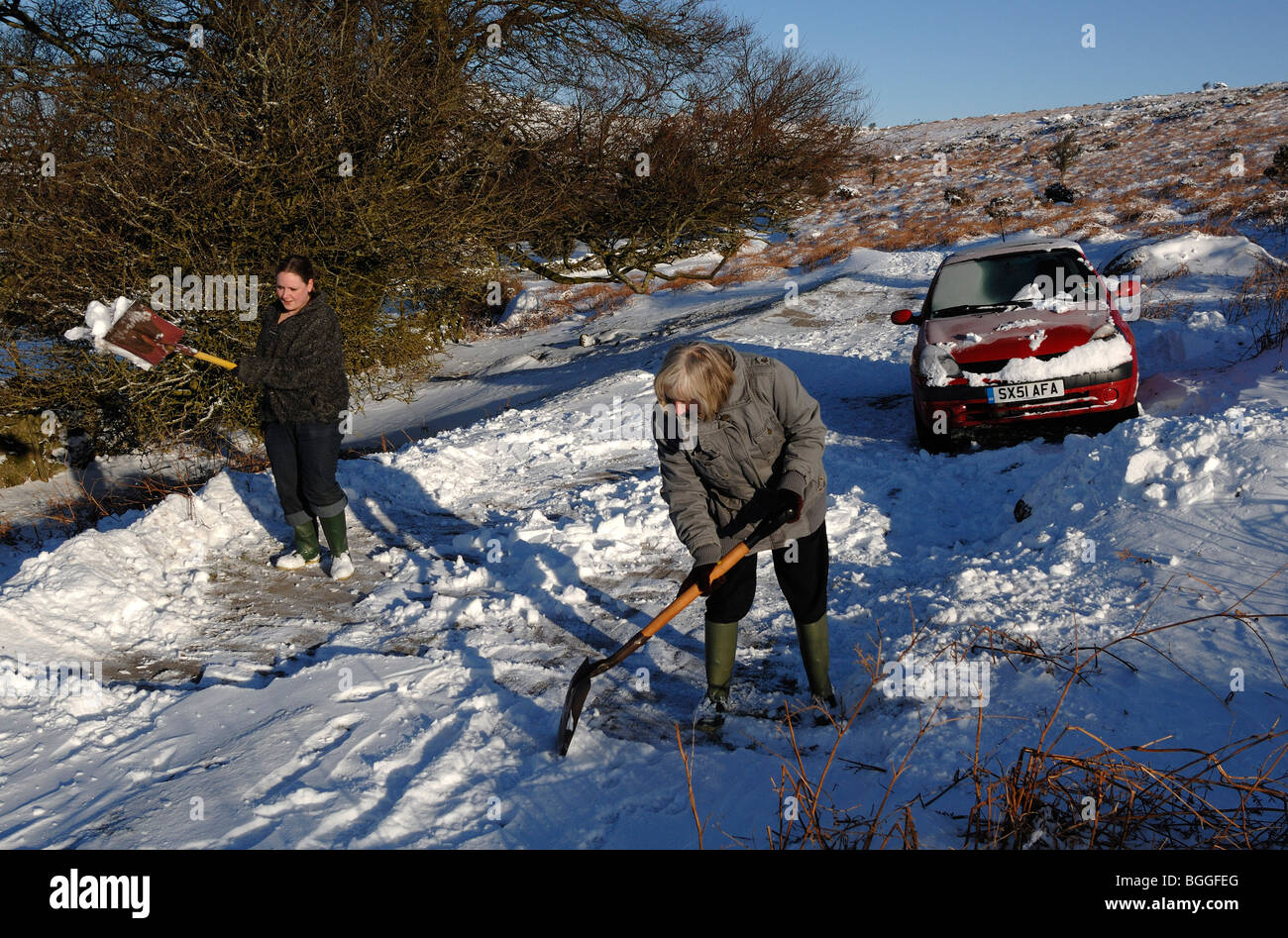 Two women digging their car out of snow near Widecome in the Moor ...
