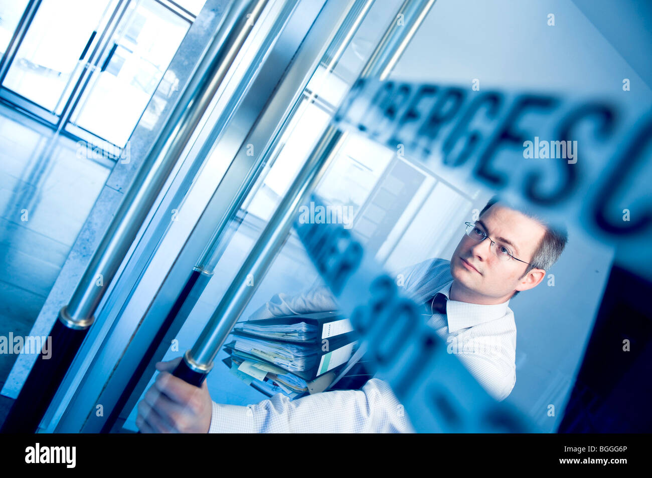Man opening a glass door, slanted Stock Photo - Alamy