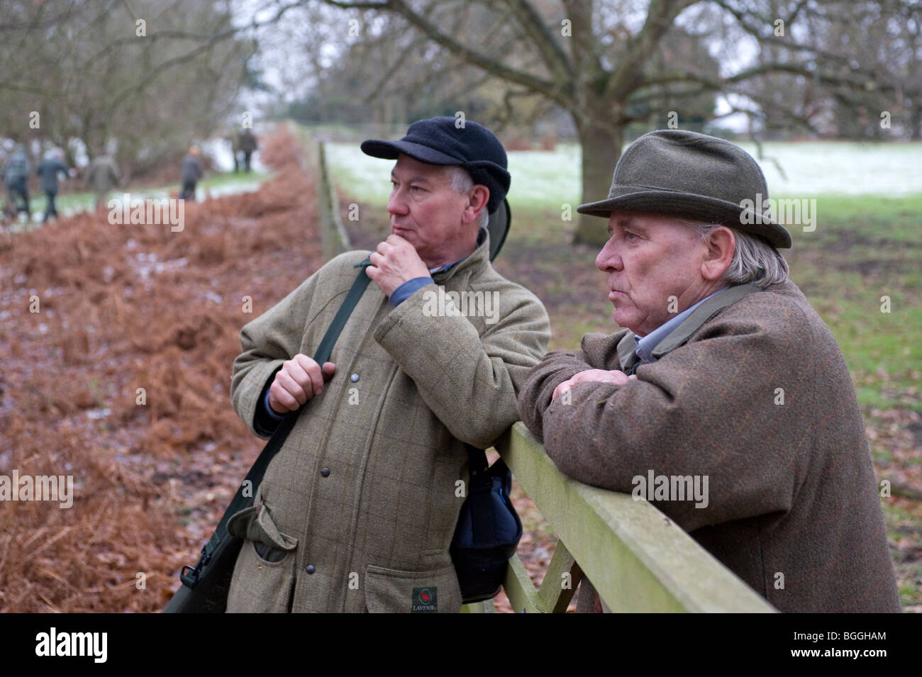 two men talking in countryside leaning of wooden farm gate Stock Photo ...