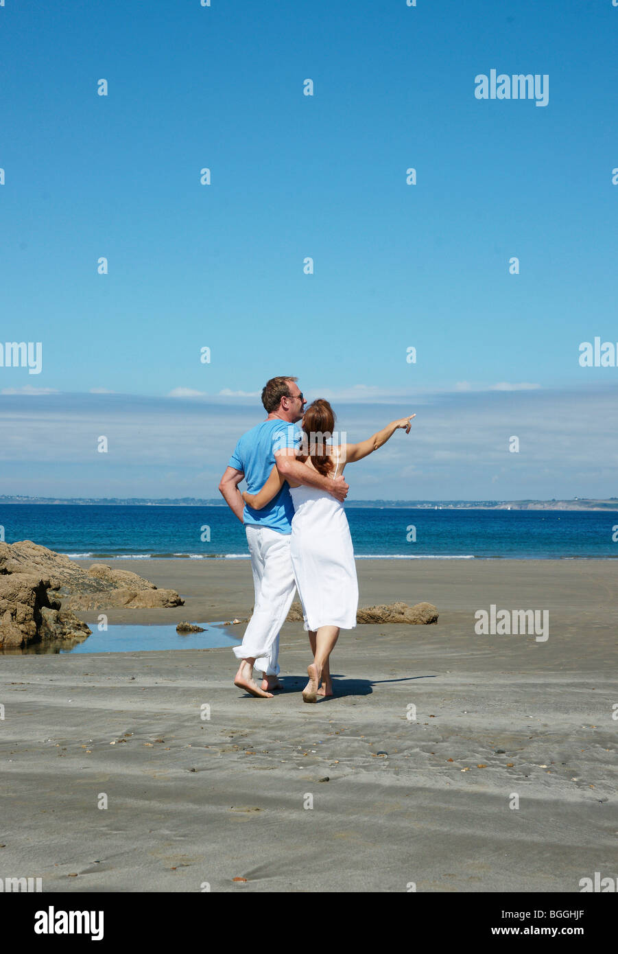 Couple walking along the beach, rear view Stock Photo - Alamy