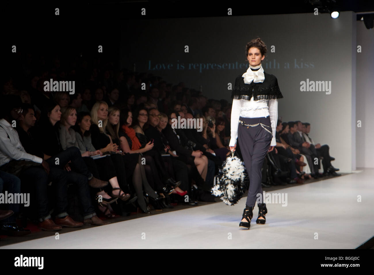 Female models wearing fashion designs walking on the runway with an ...