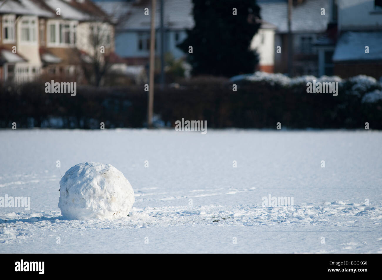 Giant snowball in snow covered field with houses in distance Stock ...