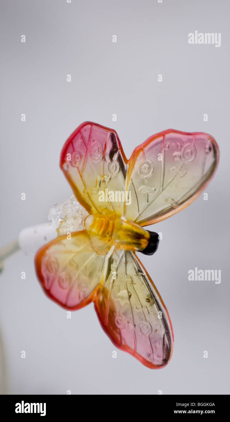 Illuminated plastic butterflies powered from a solar panel with snow in ...