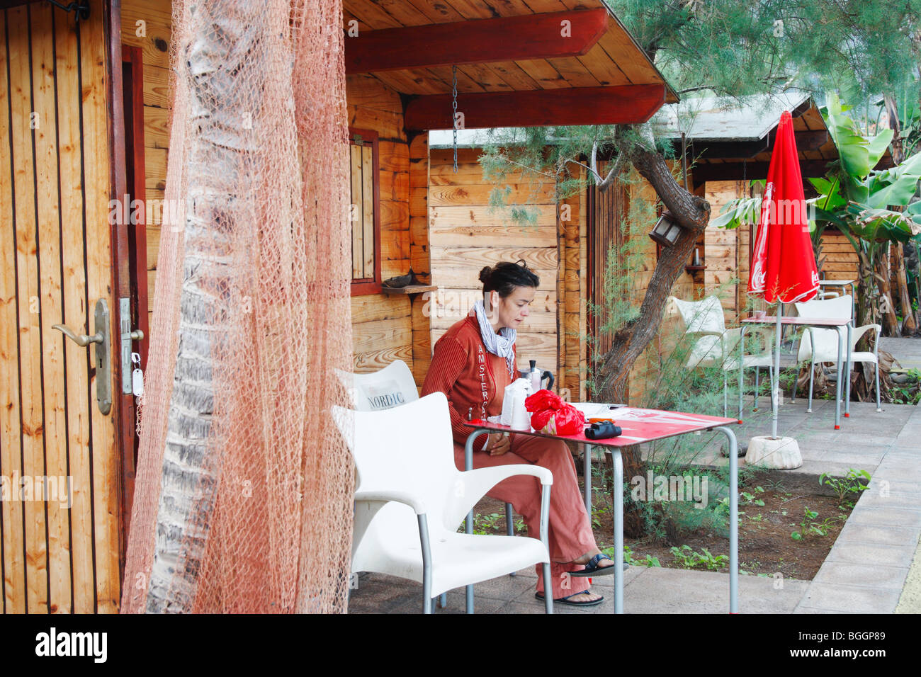 Woman sitting outside log cabin hi-res stock photography and images - Alamy