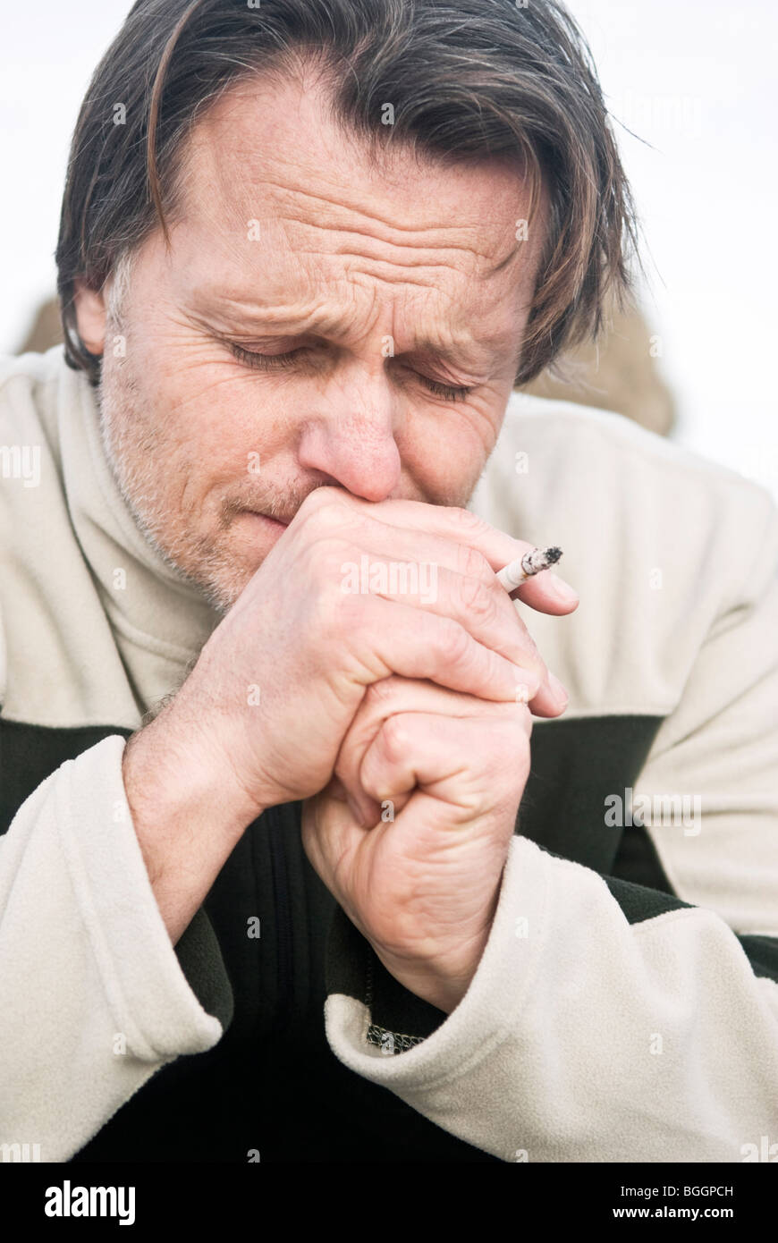 A colour portrait photo of a depressed man smoking a cigarette Stock ...