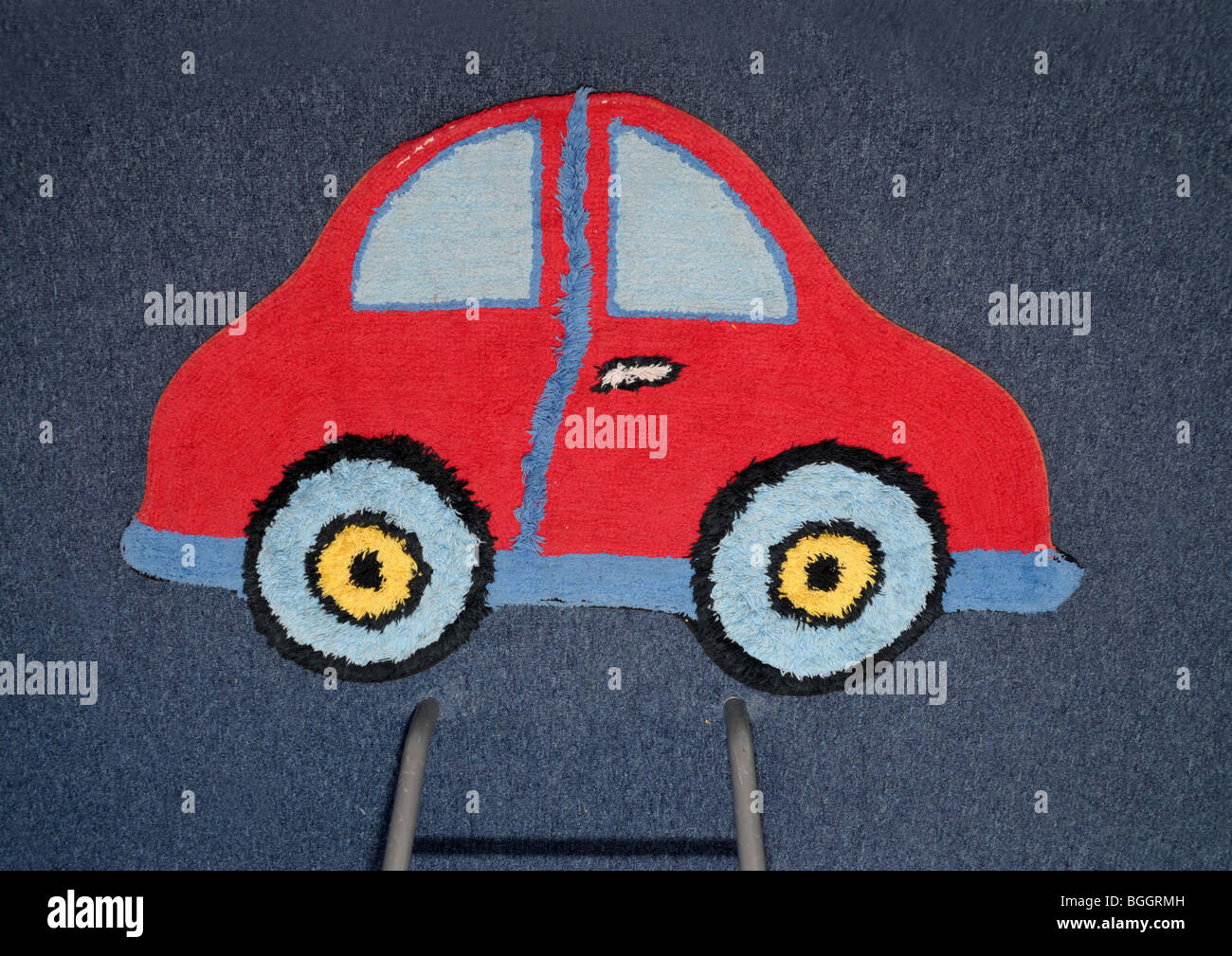 a childs bedside rug in the shape of a red car with the base of the ...