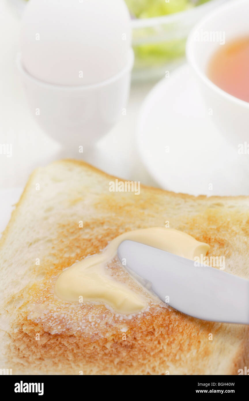 Table knife spreading butter on toast Stock Photo - Alamy
