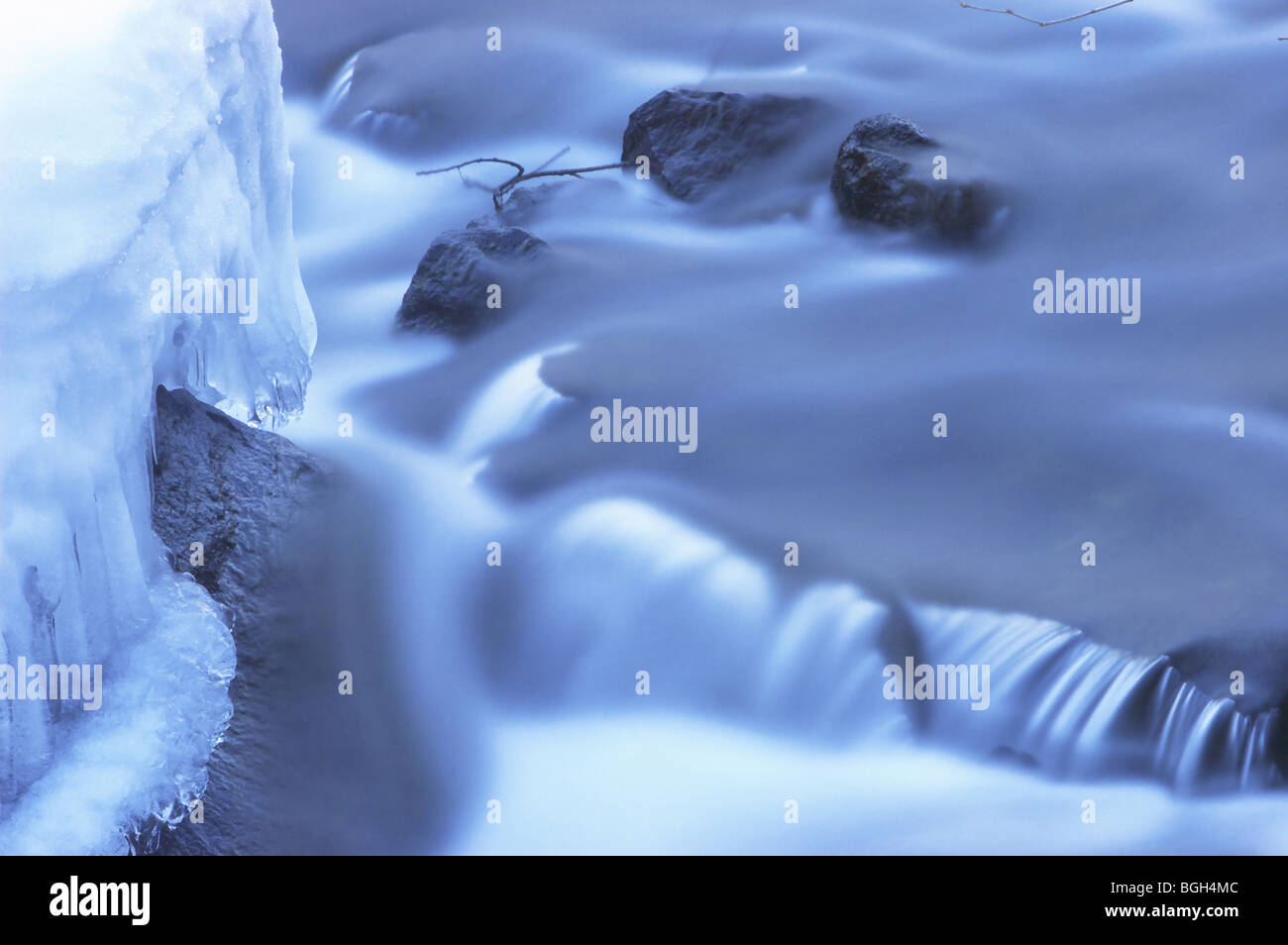 Snow on rocks in river Stock Photo - Alamy