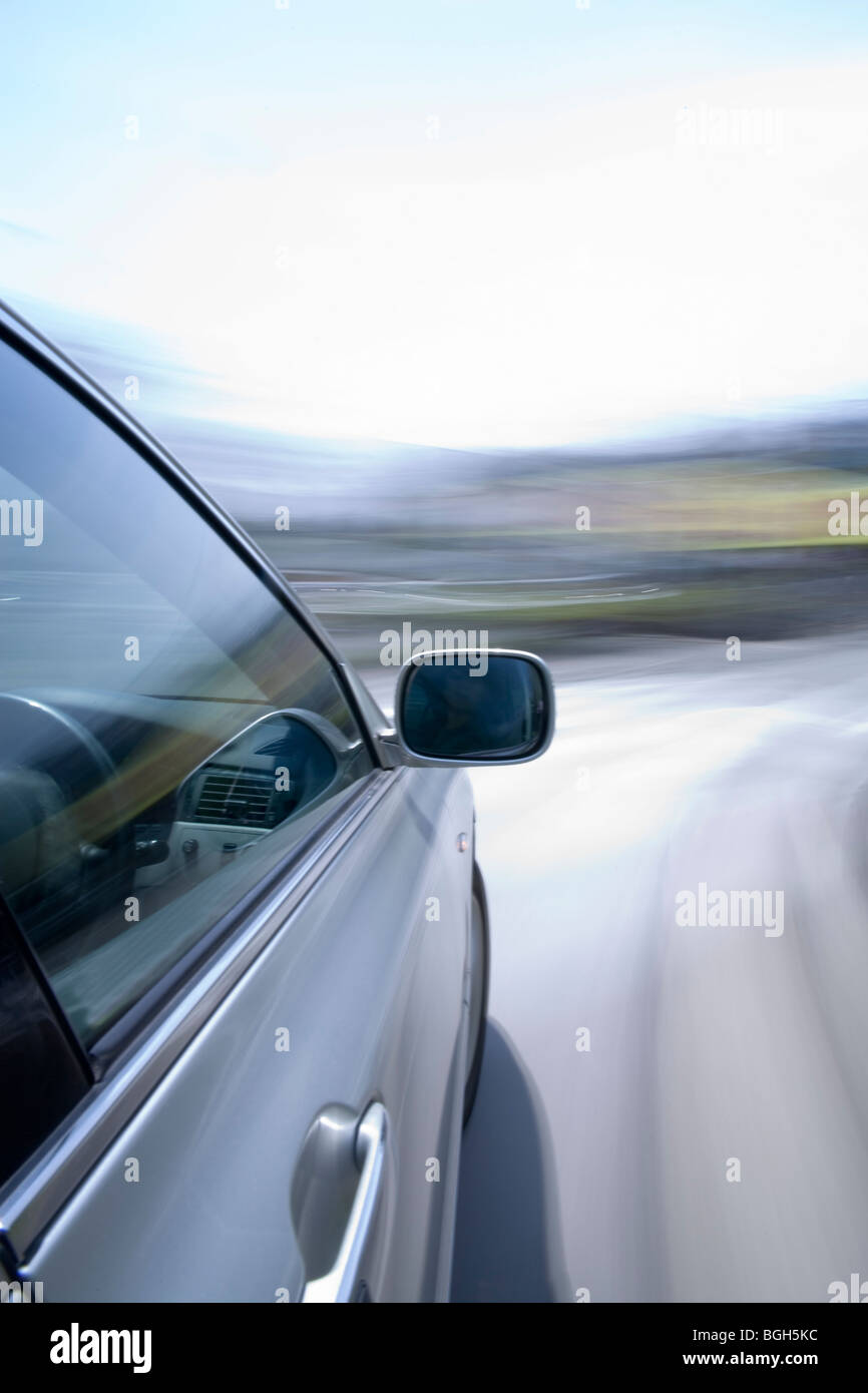 Car driving around a bend in the road Stock Photo - Alamy