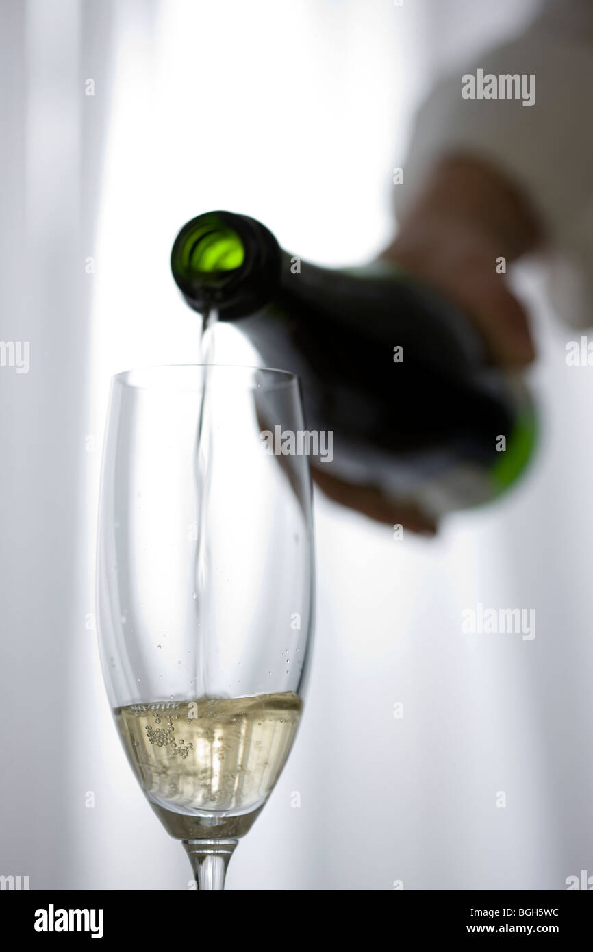 Hand pouring champagne into champagne flute Stock Photo - Alamy