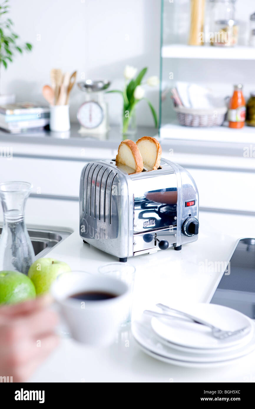 Toaster on kitchen counter and hand holding coffee cup Stock Photo - Alamy