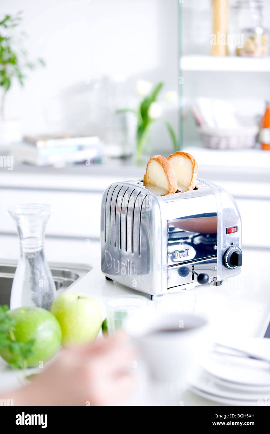 Toaster on kitchen counter and hand holding coffee cup Stock Photo - Alamy