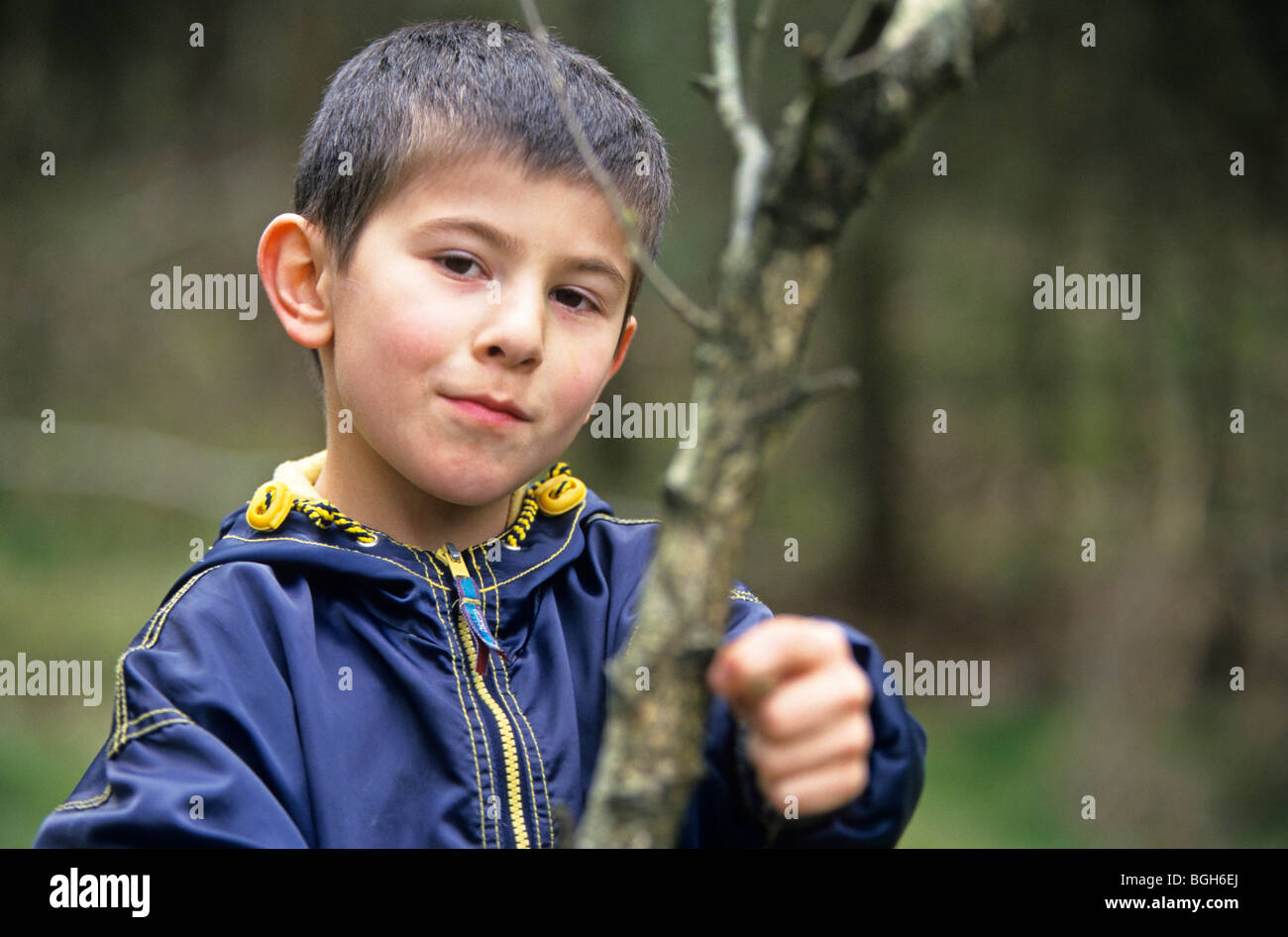 portrait of a young boy playing with a stick Stock Photo - Alamy