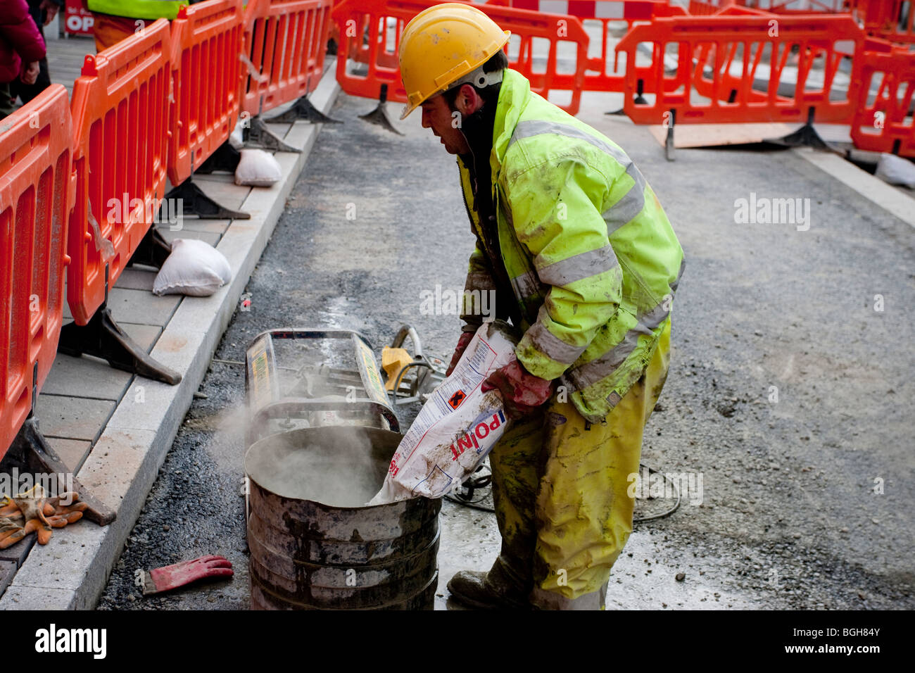 Concrete & cement being prepared by spade & shovel and hand powered ...