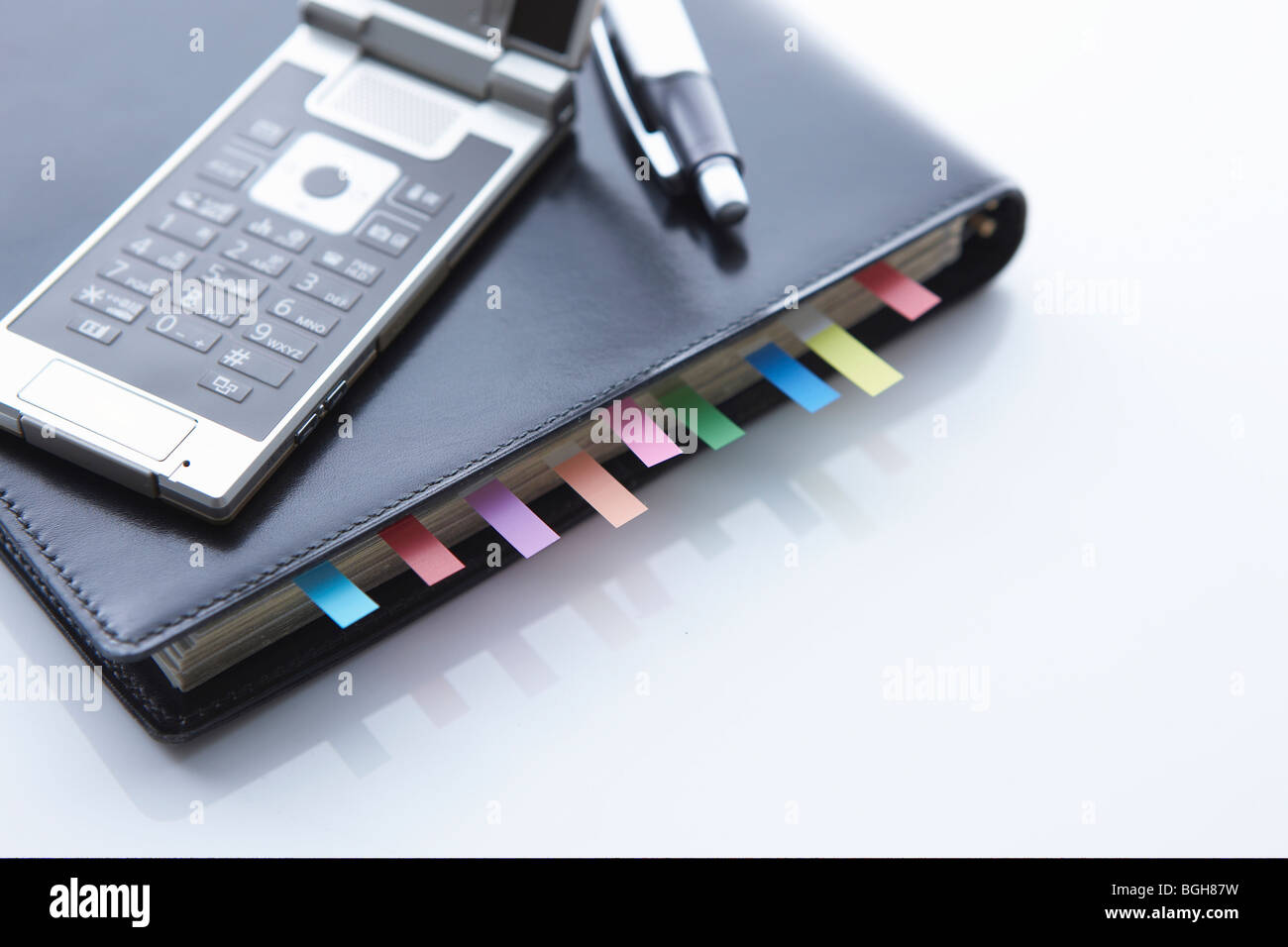 Office diary marked with coloured tabs a pen and a cellphone Stock ...
