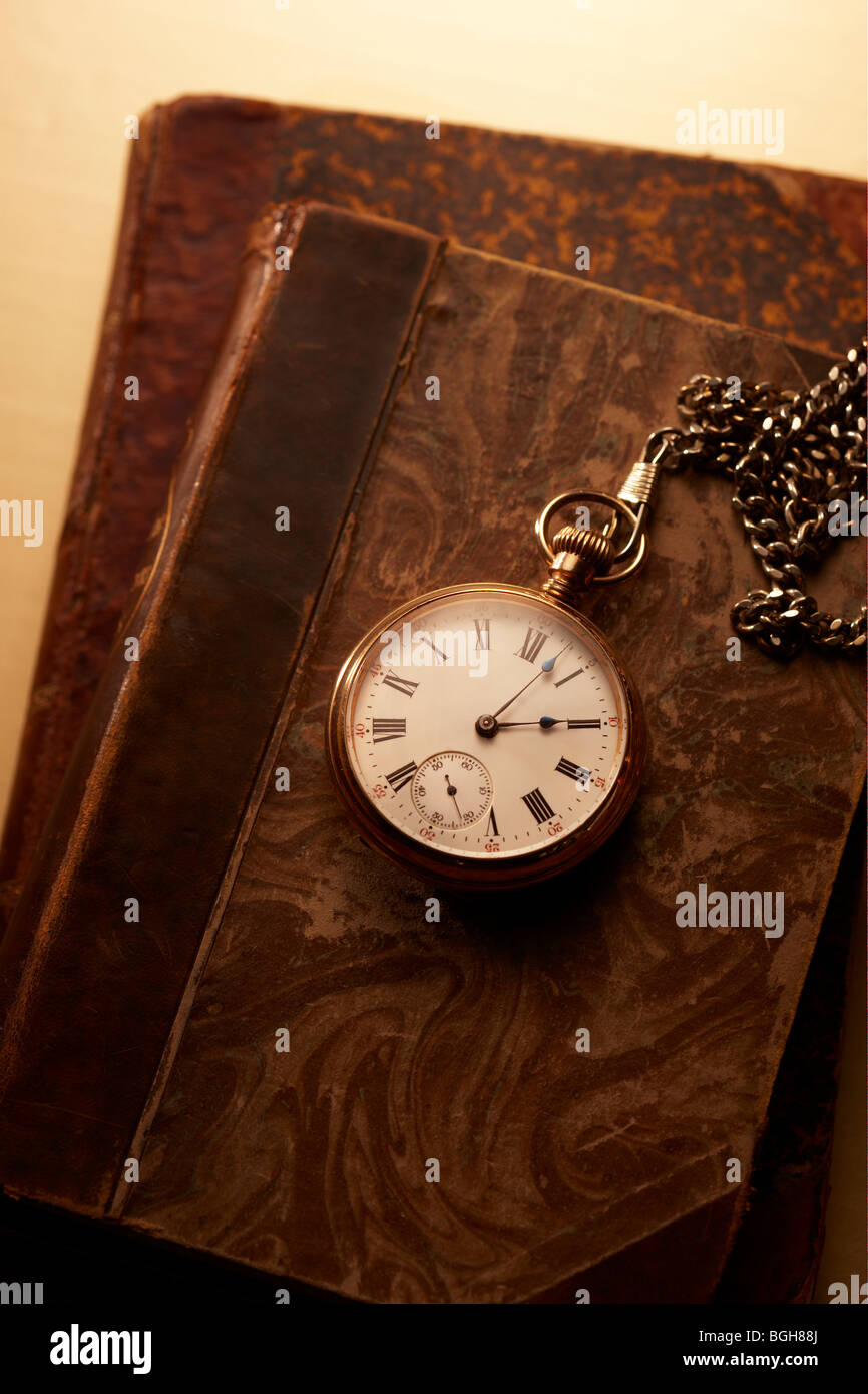 Antique pocket watch on books Stock Photo - Alamy