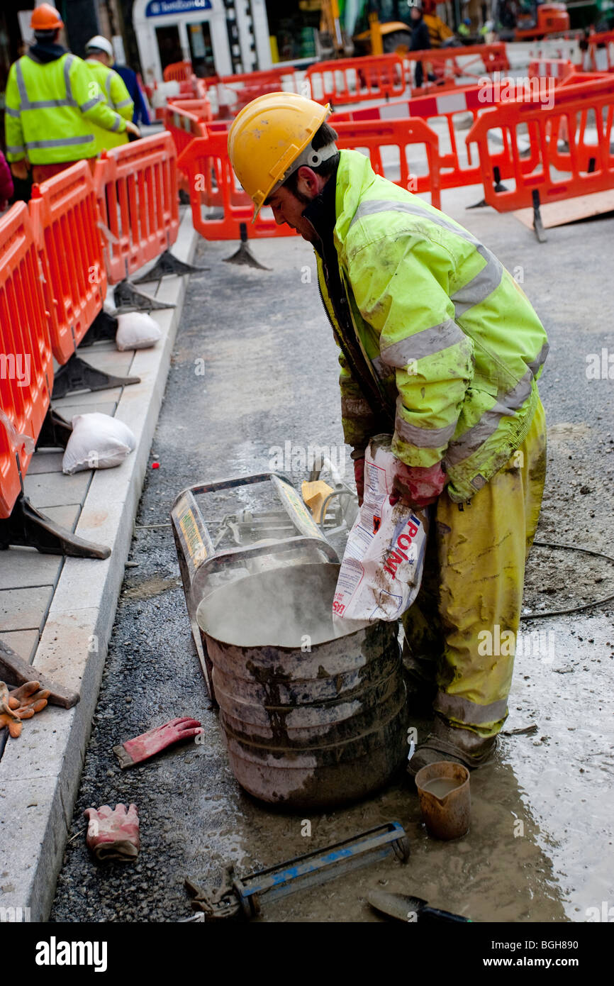 Concrete & cement being prepared by spade & shovel and hand powered ...