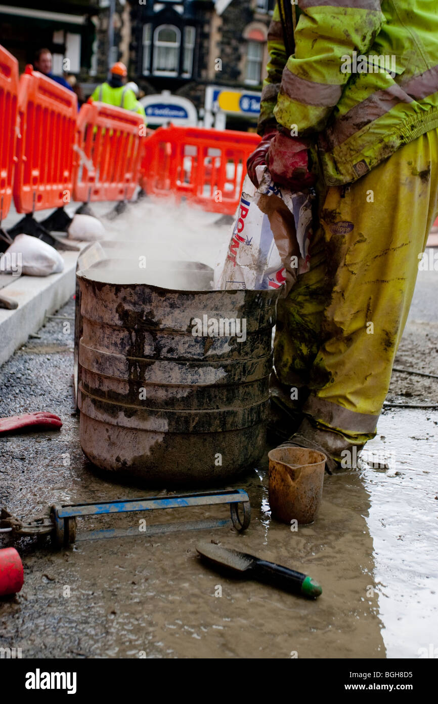Concrete & cement being prepared by spade & shovel and hand powered ...