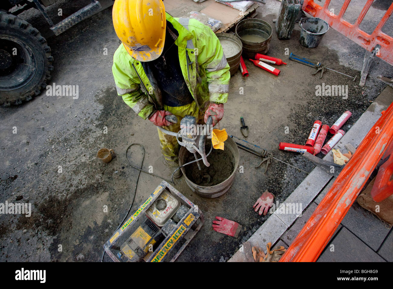 Concrete & cement being prepared by spade & shovel and hand powered ...