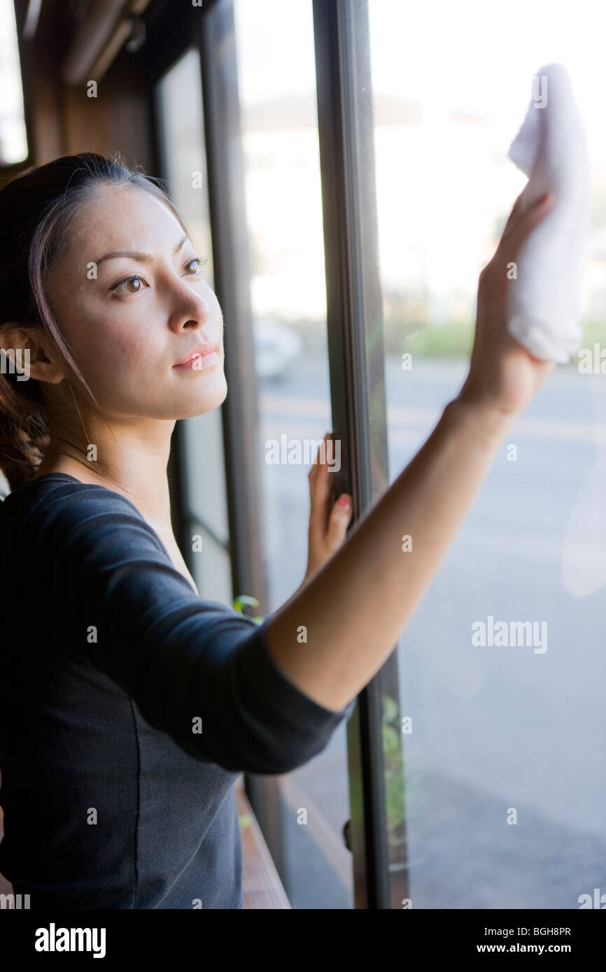 Young Woman Wiping Window Stock Photo - Alamy