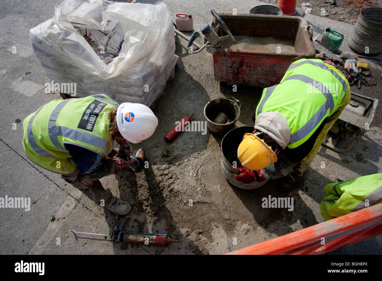 Concrete & cement being prepared by spade & shovel and hand powered ...