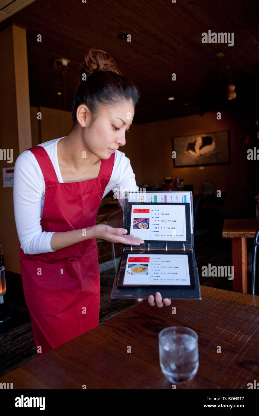 Mid Adult Woman Showing Menu at Table Stock Photo - Alamy