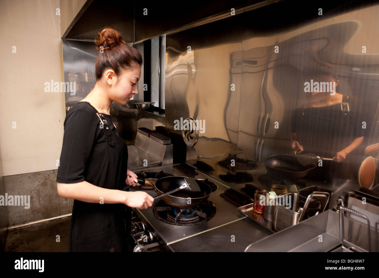 Young Woman Cooking at Kitchen in Restaurant Stock Photo - Alamy