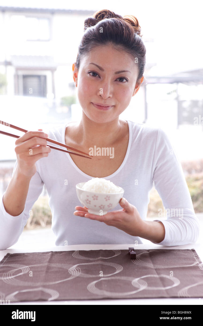 Woman eating rice vertical hi-res stock photography and images - Alamy