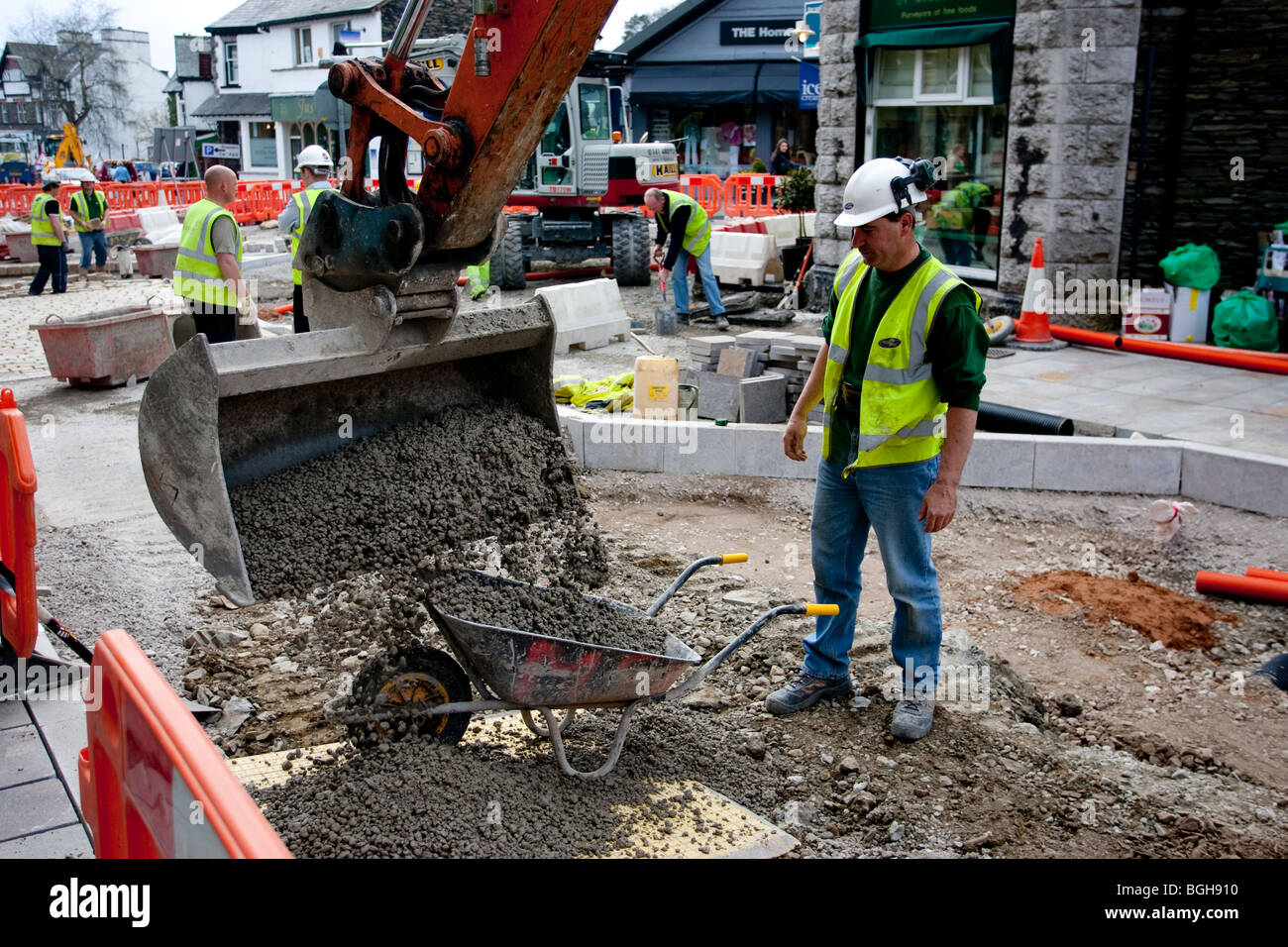 Concrete & cement being prepared by spade & shovel and hand powered ...