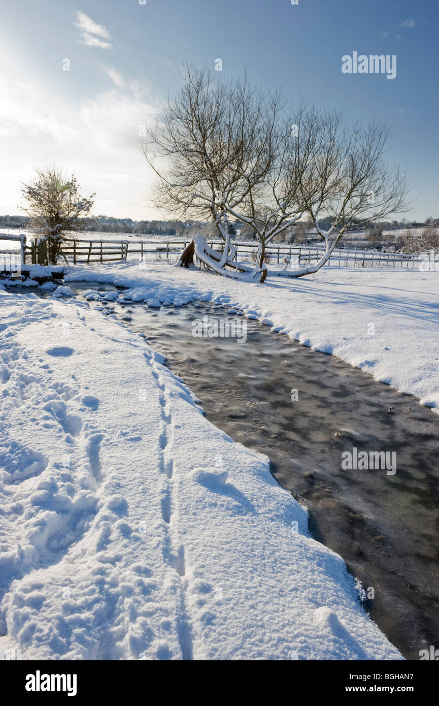 the River Misbourne flowing through Winter snow covered Chilterns ...
