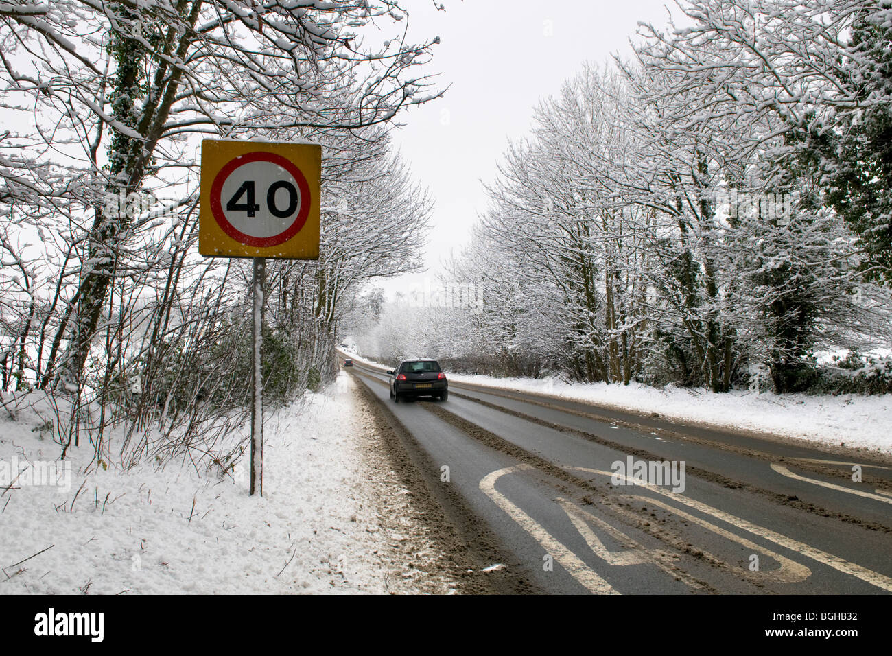 Snowy road scene along the A46 with forty speed limit road sign on the ...