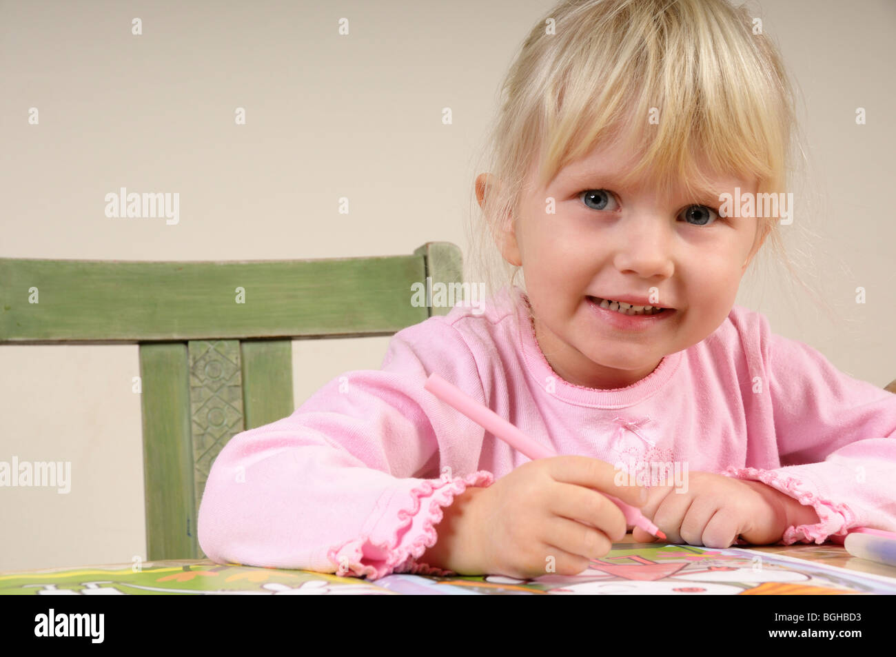 Stock photo of a four year old girl drawing pictures on a piece of ...