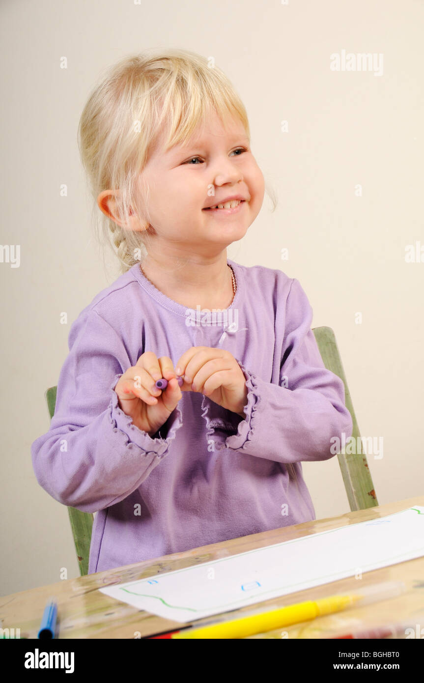 Stock photo of a four year old girl drawing pictures on a piece of ...