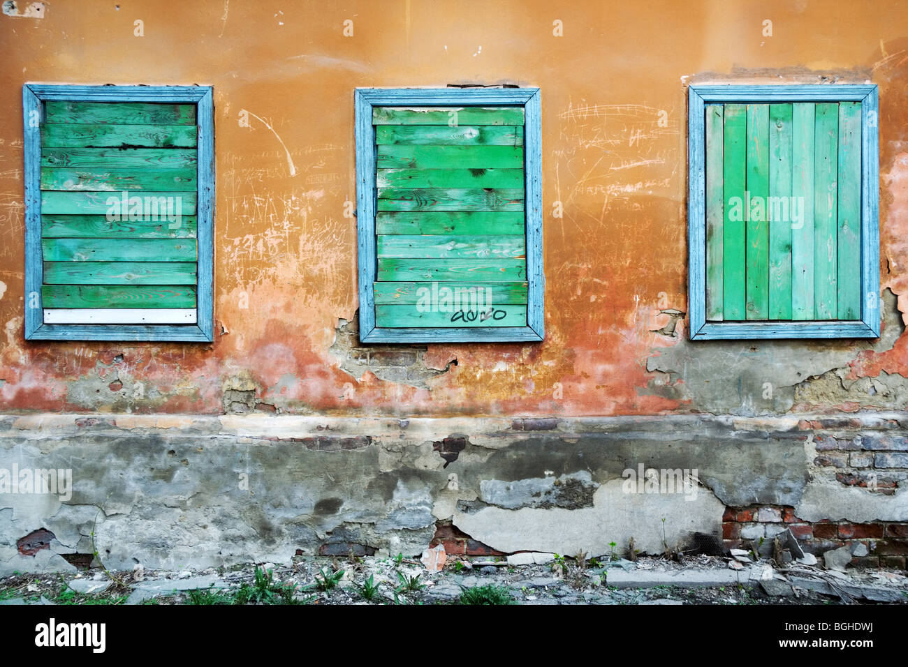 Three boarded up windows of an old rundown building Stock Photo - Alamy