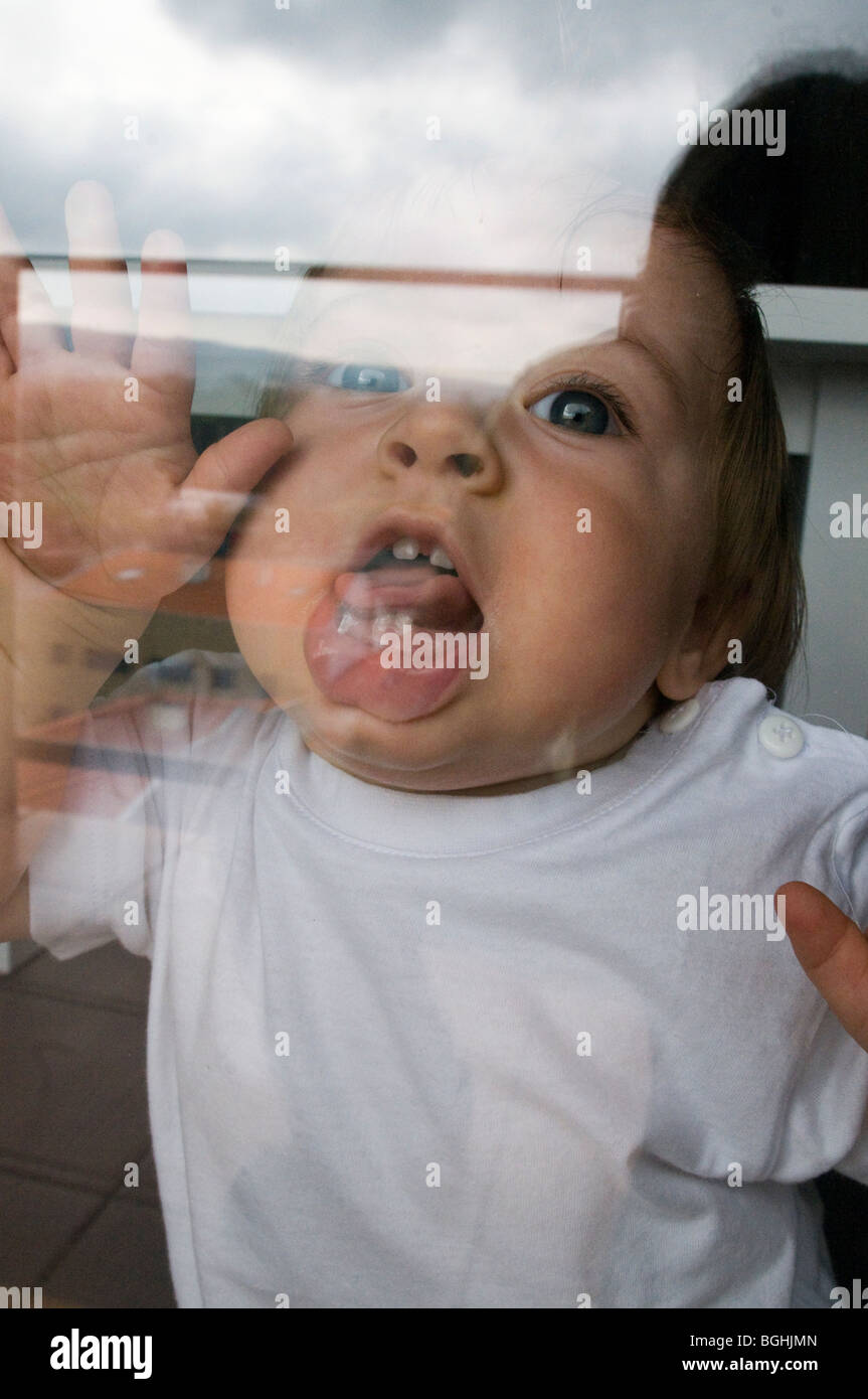 one year old baby looking through the window Stock Photo - Alamy