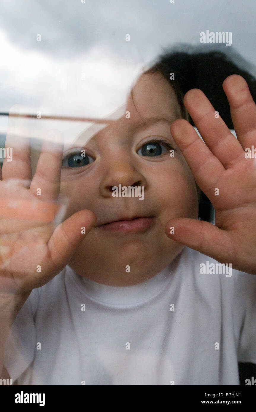 one year old baby looking through the window Stock Photo - Alamy