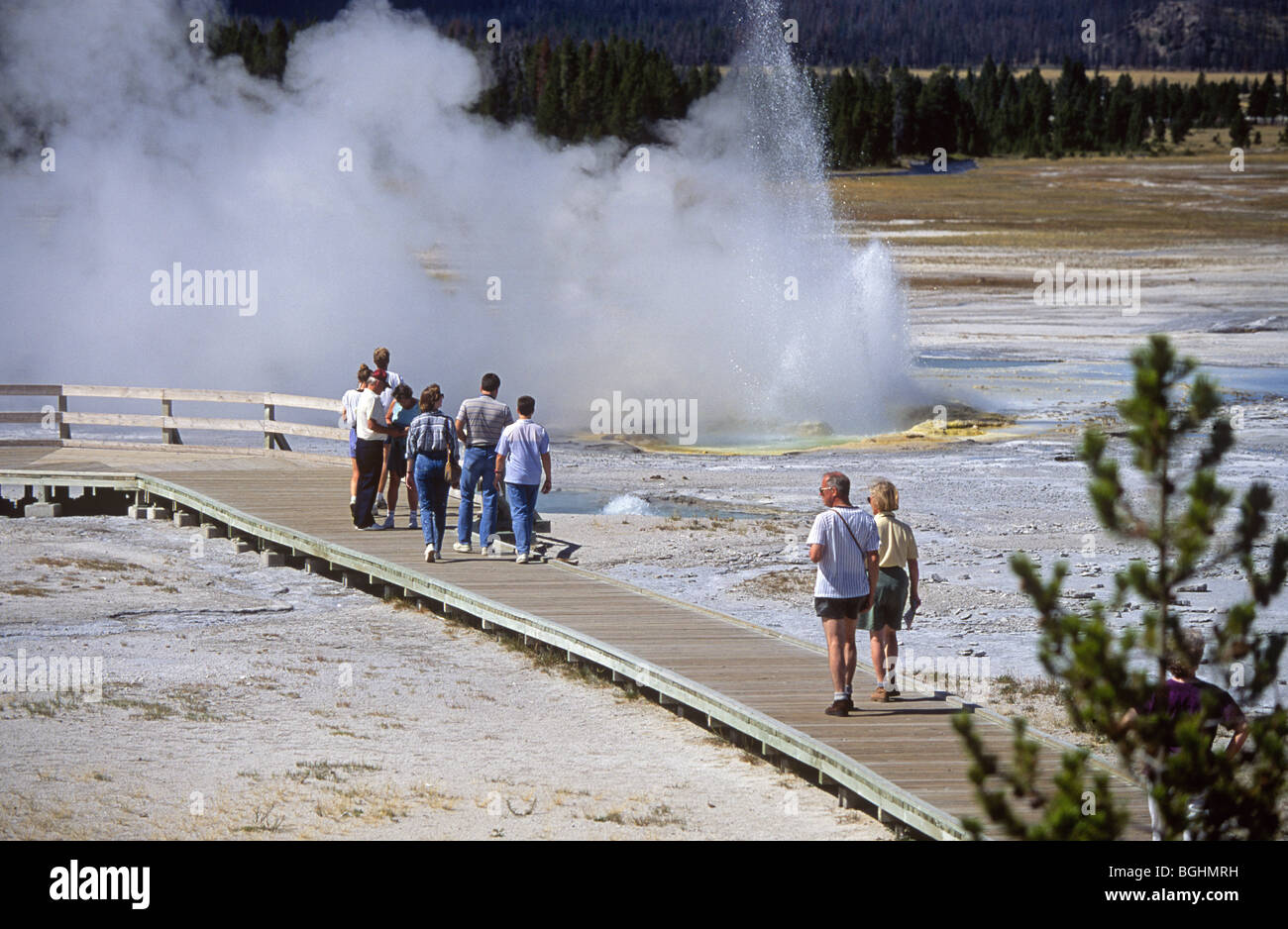 Tourists walk through a geyser basin near Old Faithful, in Yellowstone ...