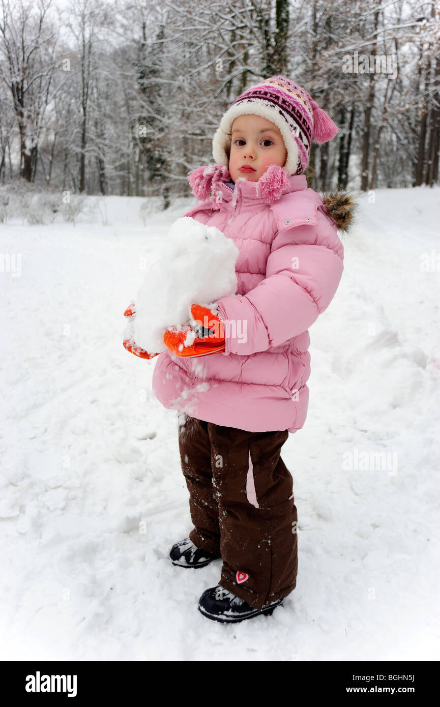 Child girl playing in winter park with snow Stock Photo - Alamy