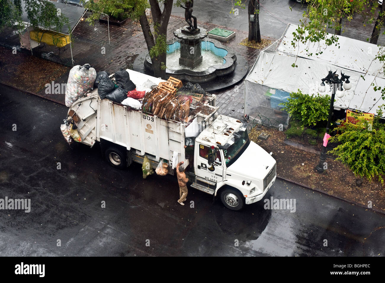 overburdened garbage truck with packaged recyclables piled on roof ...