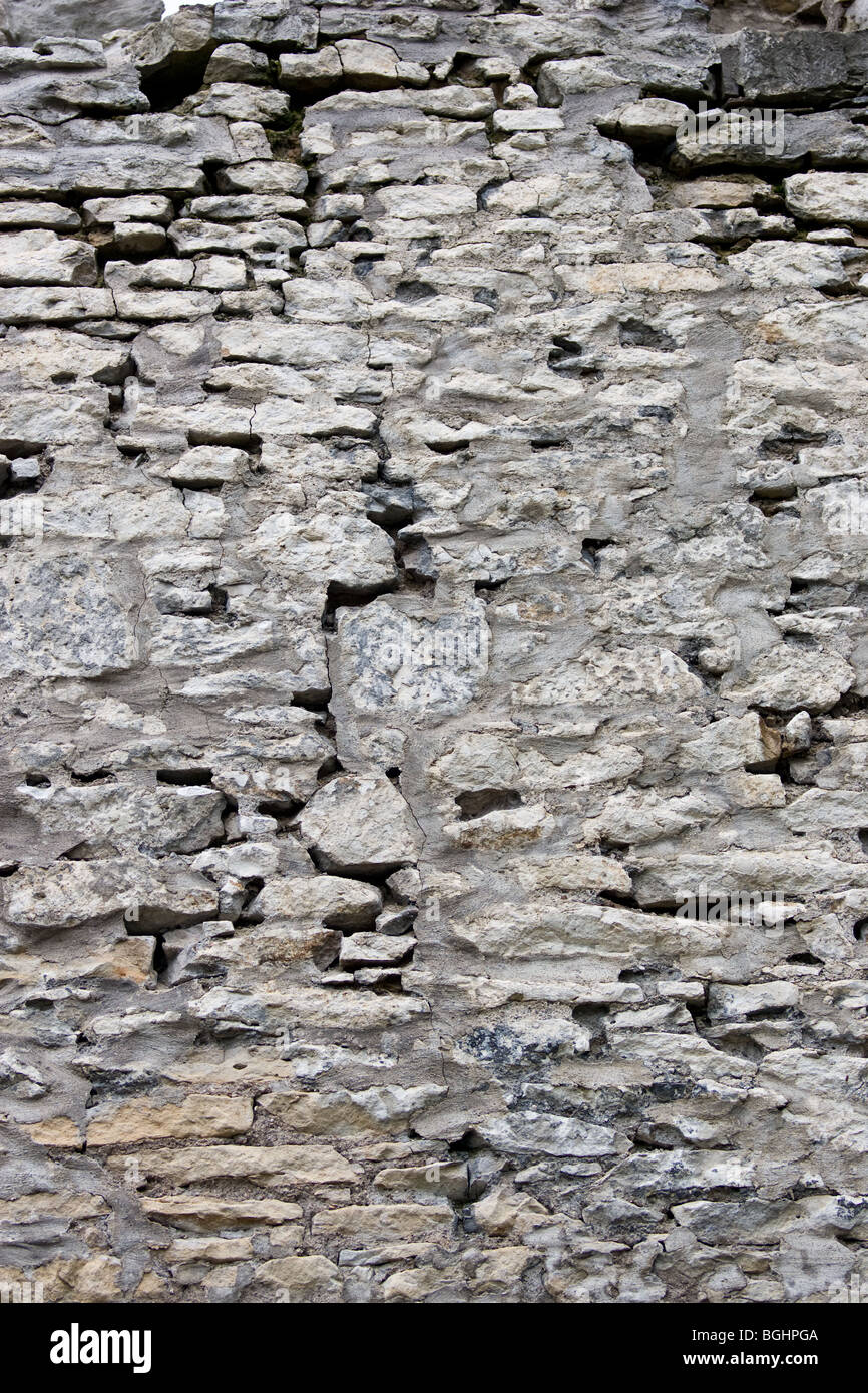 A closeup of an old dilapidated wall, mortar missing from many joints ...