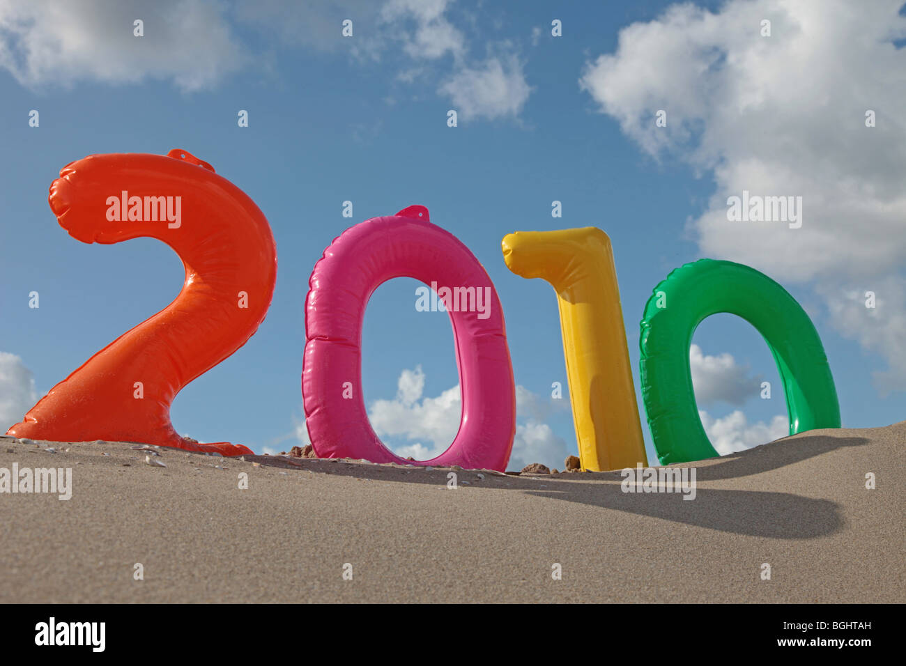 The year 2010 with inflatable numbers on the beach in front of a bright ...