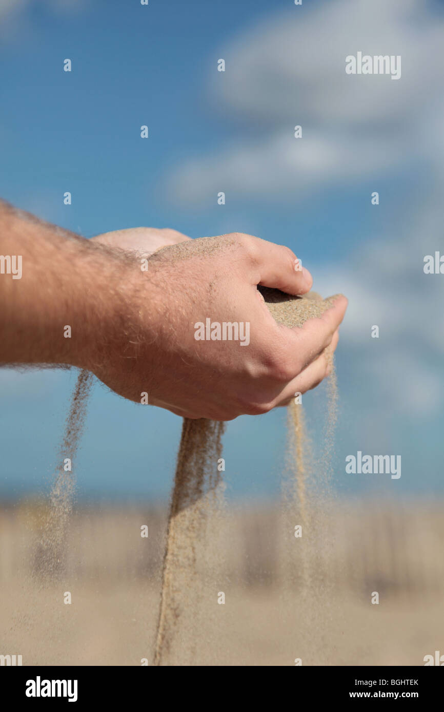 A person holding dry sand in his hands Stock Photo - Alamy