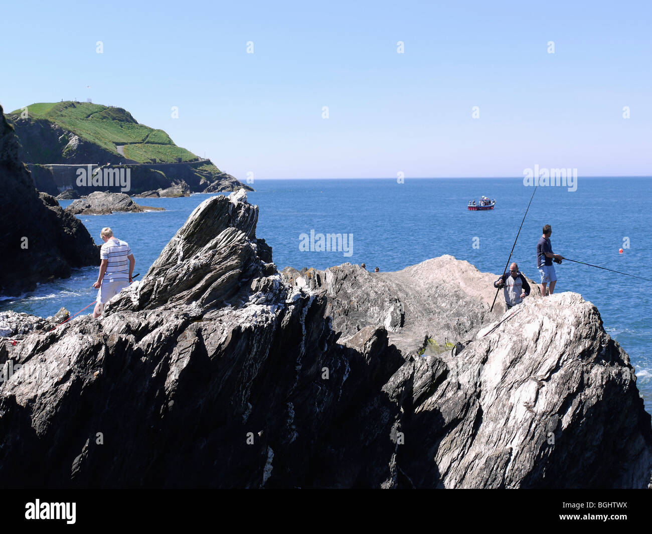 man fishing in the sea on a pier in the devon holiday town and resort ...