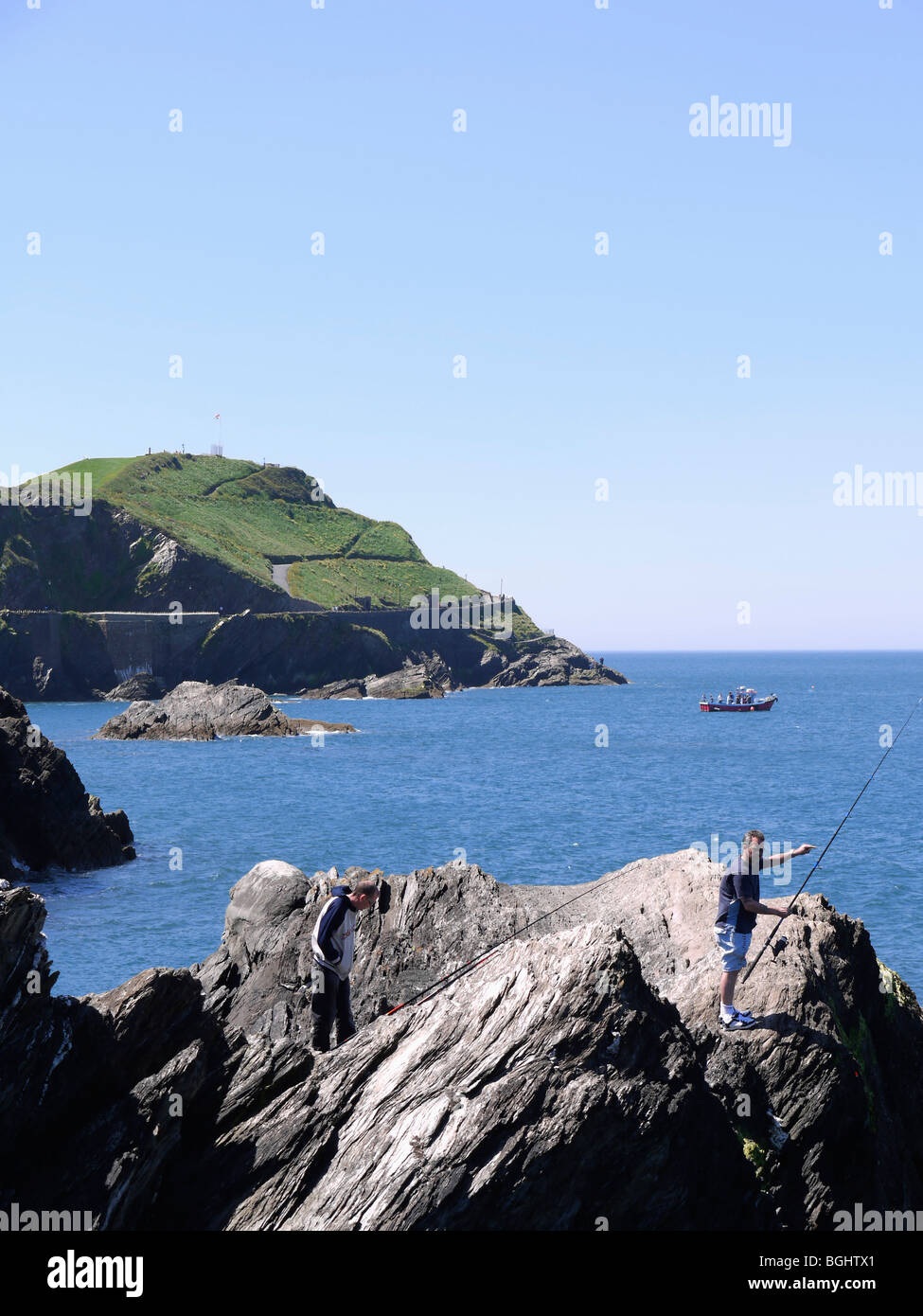 man fishing in the sea on a pier in the devon holiday town and resort ...