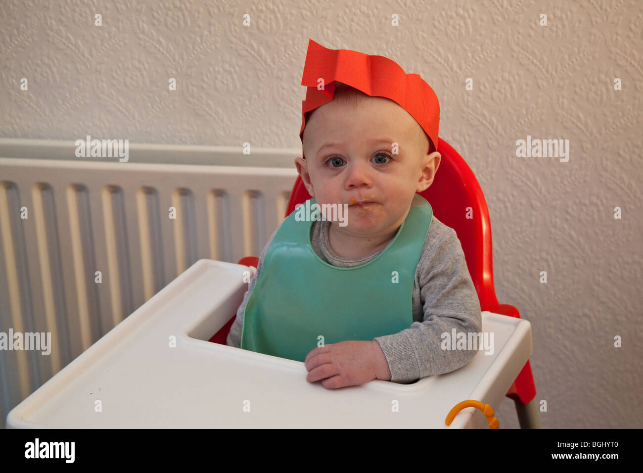 Baby boy sitting in a high chair Stock Photo - Alamy