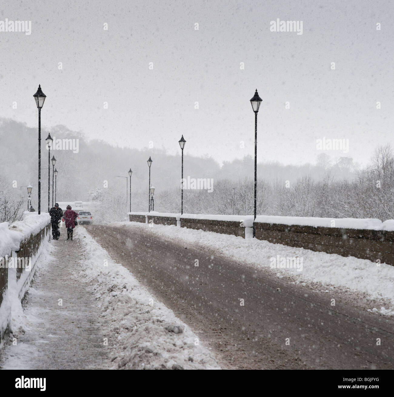Kelso Scotland in winter snow - snowflakes swirl as people cross the ...